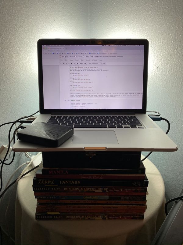 macbook on book stack : Global Nerdy
